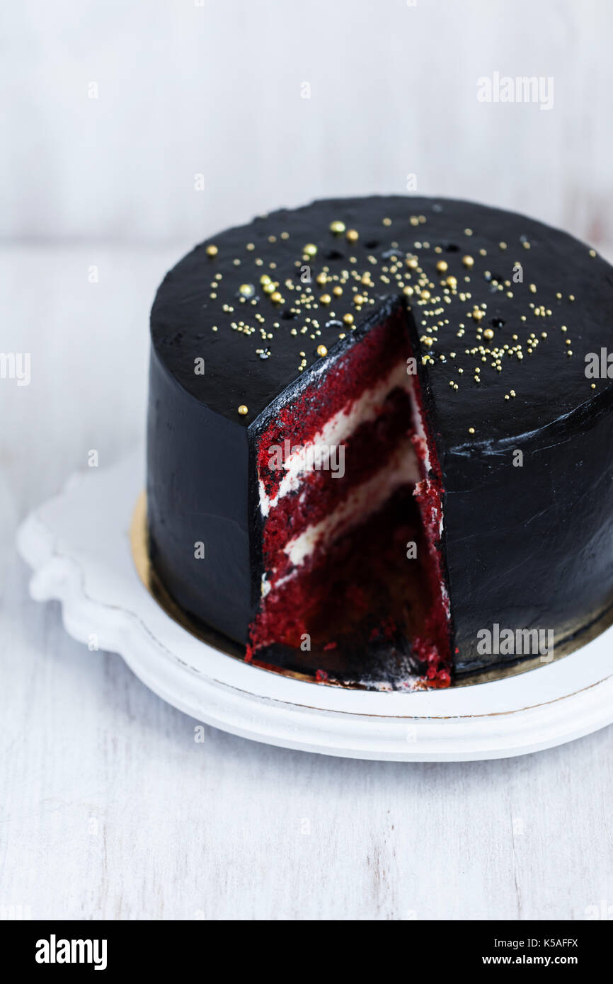 Round black cake with striped red and white filling Stock Photo - Alamy