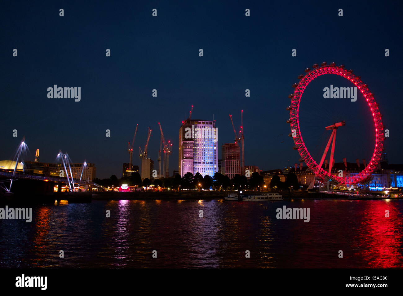 Street light by River Thames with backdrop of London Eye lit with Neon ...