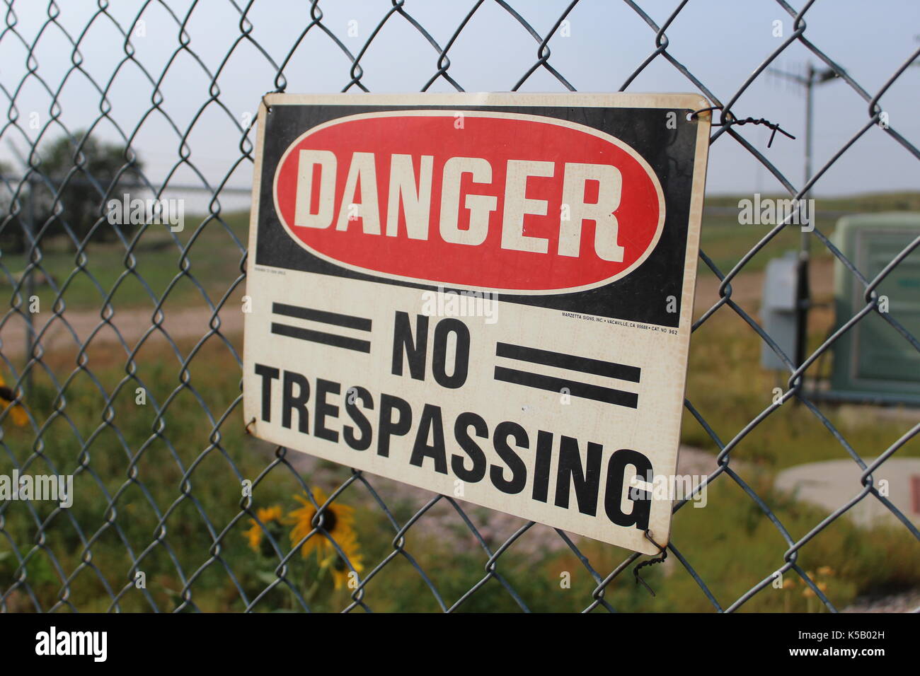 Danger sign on outside of fenced restricted area Stock Photo - Alamy