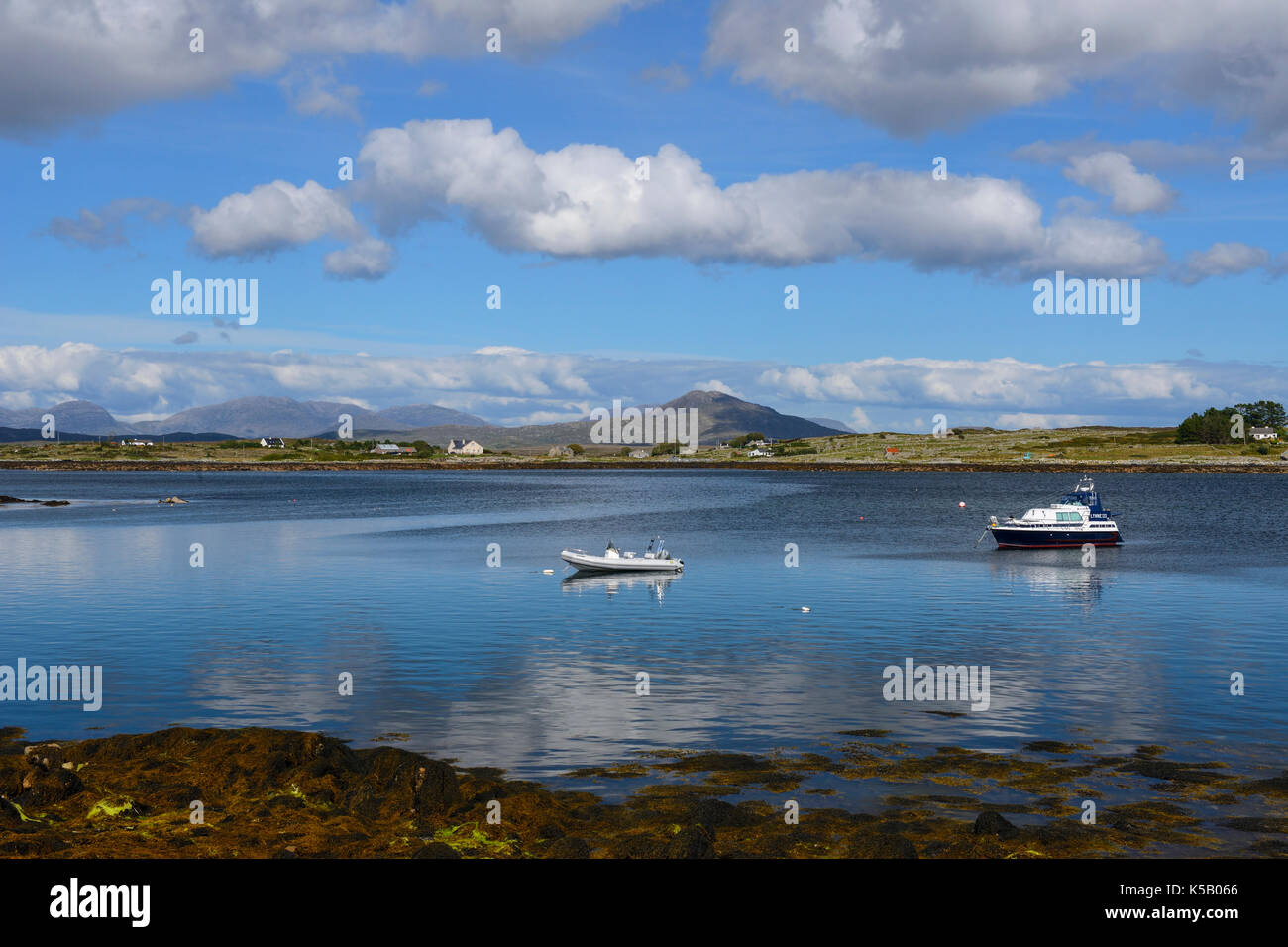 View across foreshore at Roundstone harbour to Twelve Bens Mountain ...