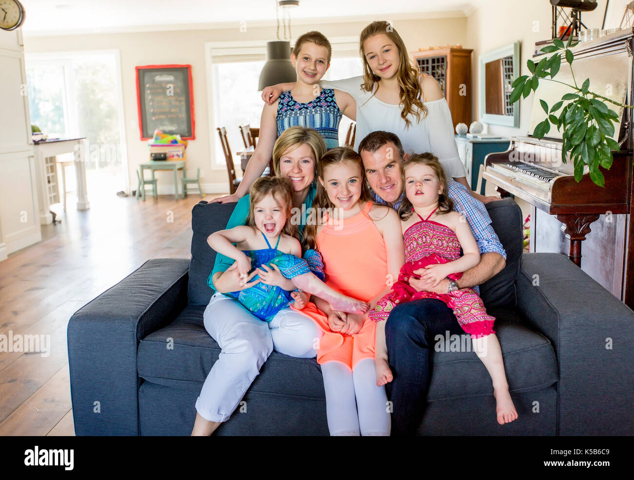 happy family sitting on couch at home Stock Photo - Alamy