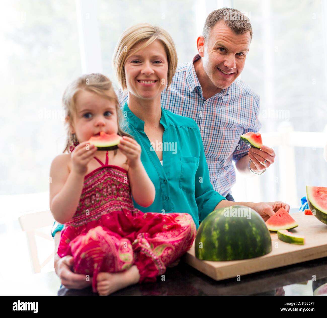 family in the kitchen cuting the watermelon Stock Photo - Alamy