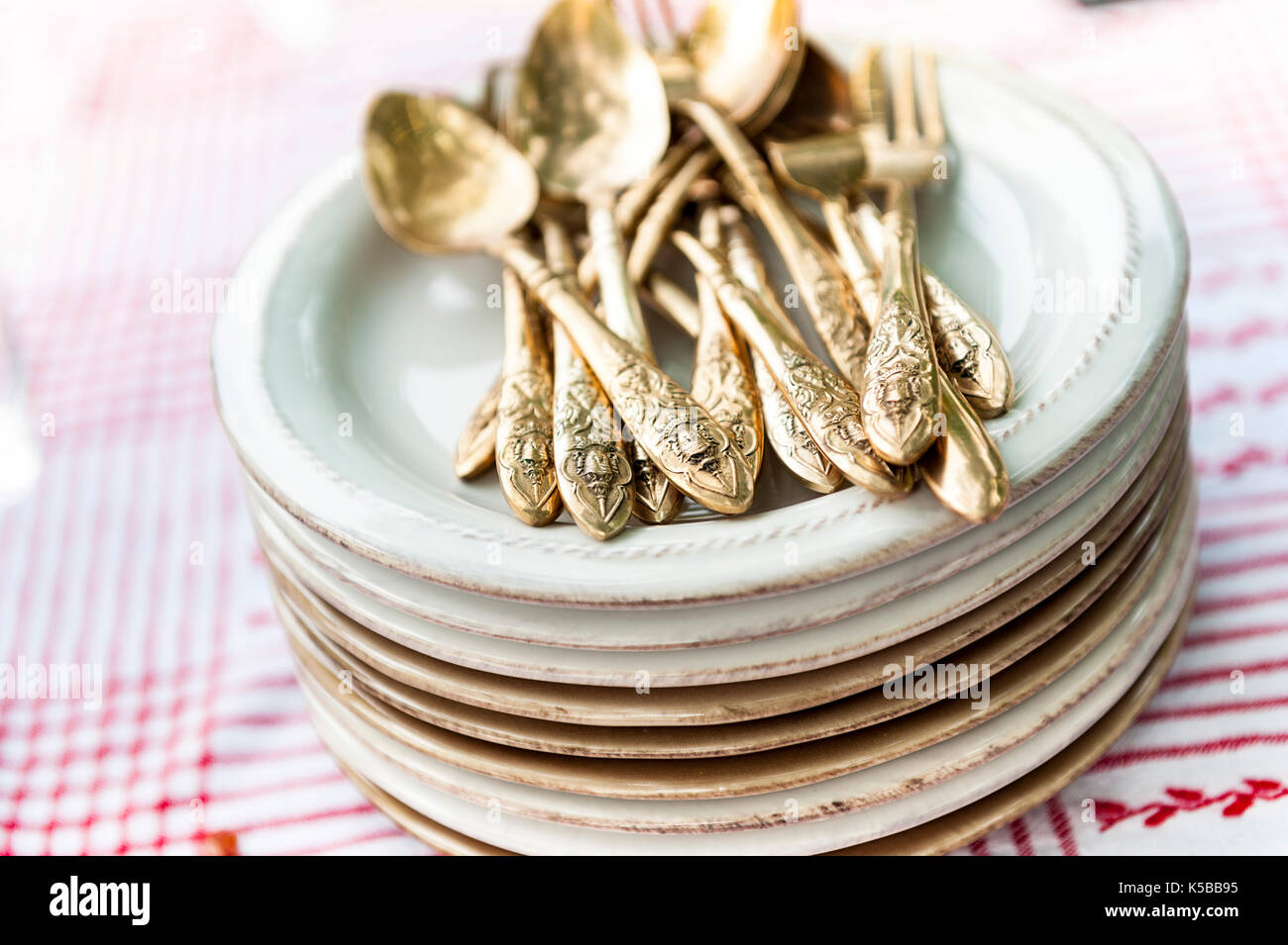 small plates with golden silverware Stock Photo - Alamy