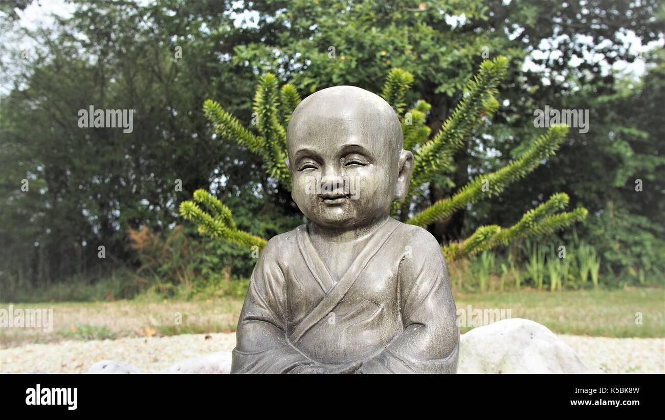 Buddhist statue zen serinity, calm garden and tree Stock Photo - Alamy