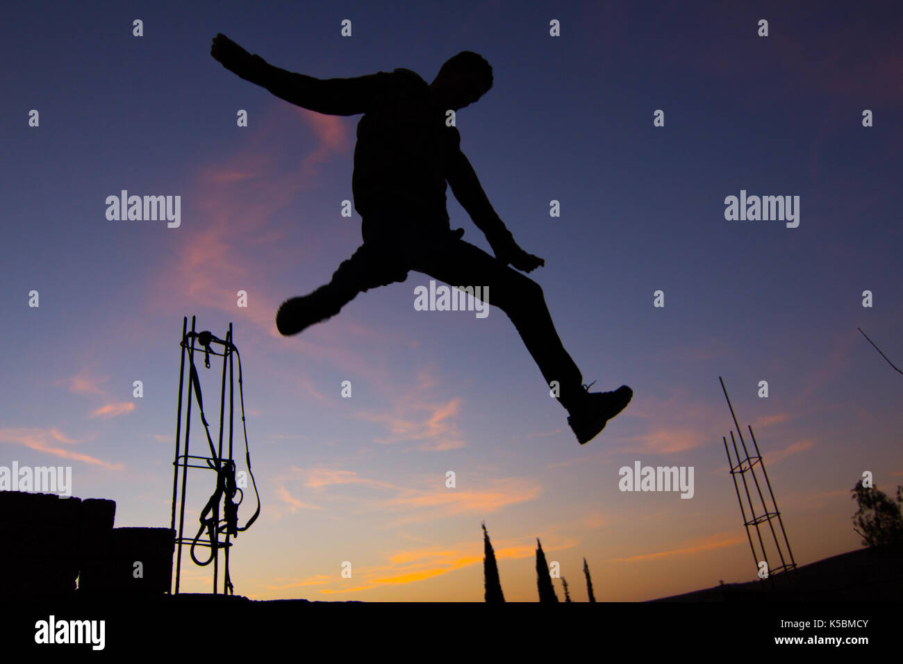 silhouette of man jumping on sunset background Stock Photo - Alamy