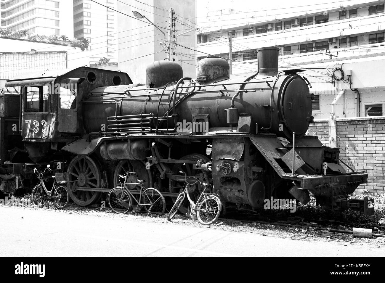 The grey of old train on railway near that have three bicycle ...