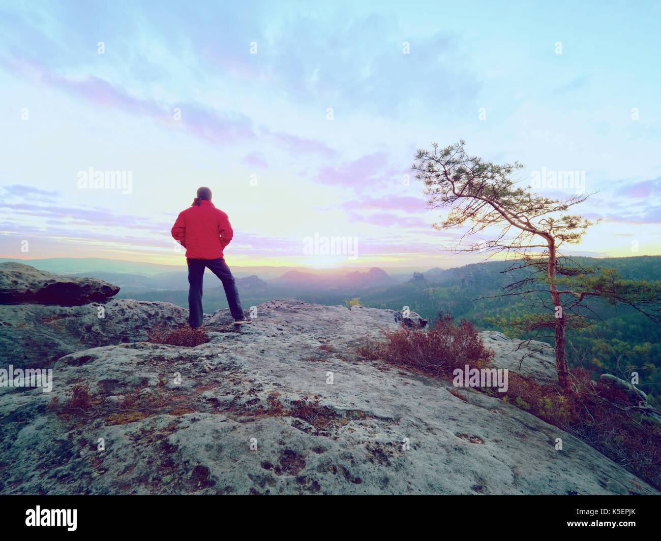 Man silhouette on cliff. Hiker in red jacket climbed up to peak enjoy ... Man silhouette on cliff. Hiker in red jacket climbed up to peak enjoy ...