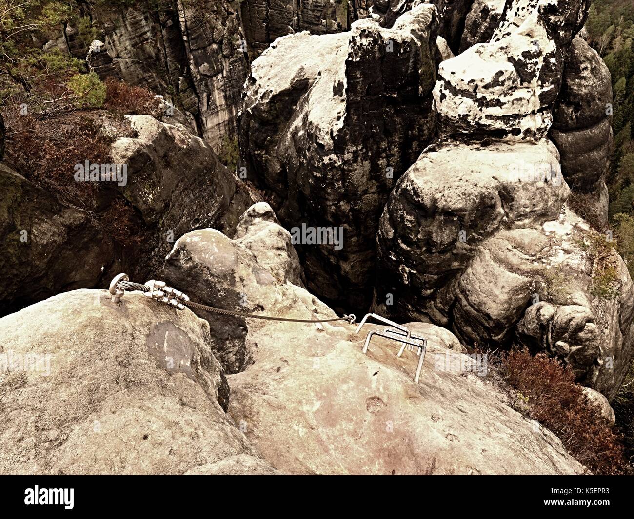 Climbers ladder. Iron twisted rope fixed in block by screws snap hooks ...