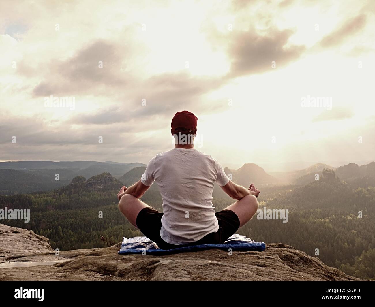 Yoga practicing at mountain summit with aerial view of the mountain ...