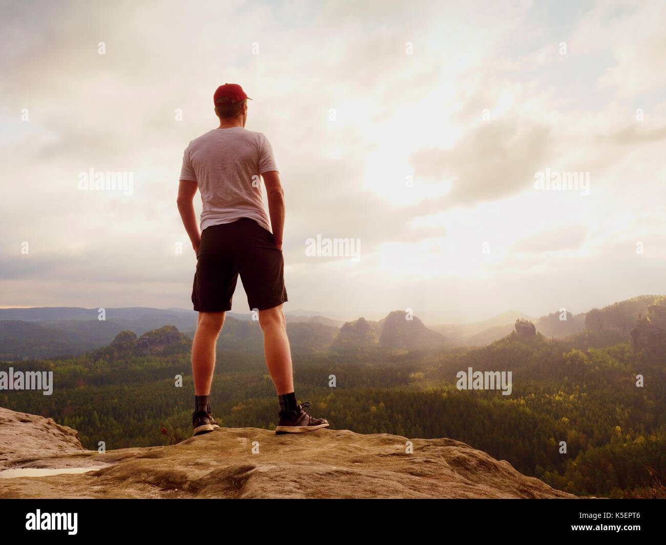 Tall man enjoy freedom on peak of mountain edge. Alone tourist watching ...