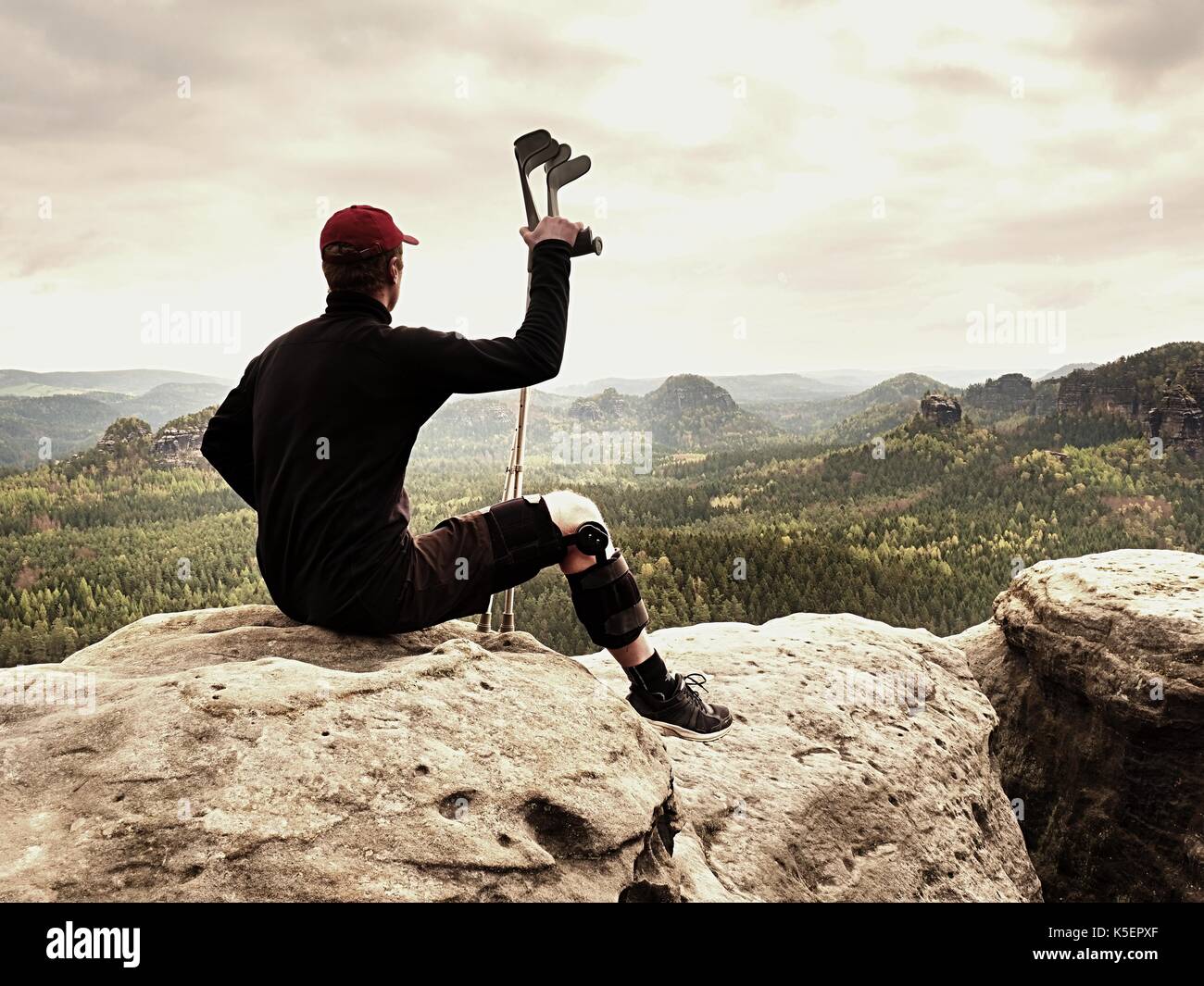 Tired hurt tourist with medicine crutches. Man with broken leg in knee ...