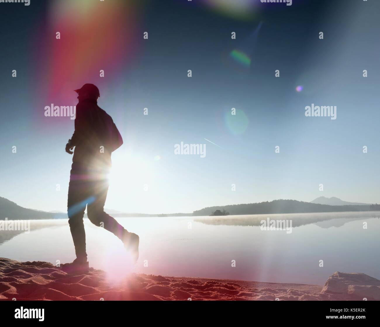 Slim young fitness man runner on beach, tropical trail runner. Cheerful ...