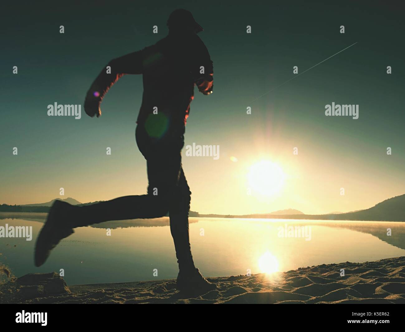 Running man. Boy quickly running on the morning beach. Sportsman runner ...