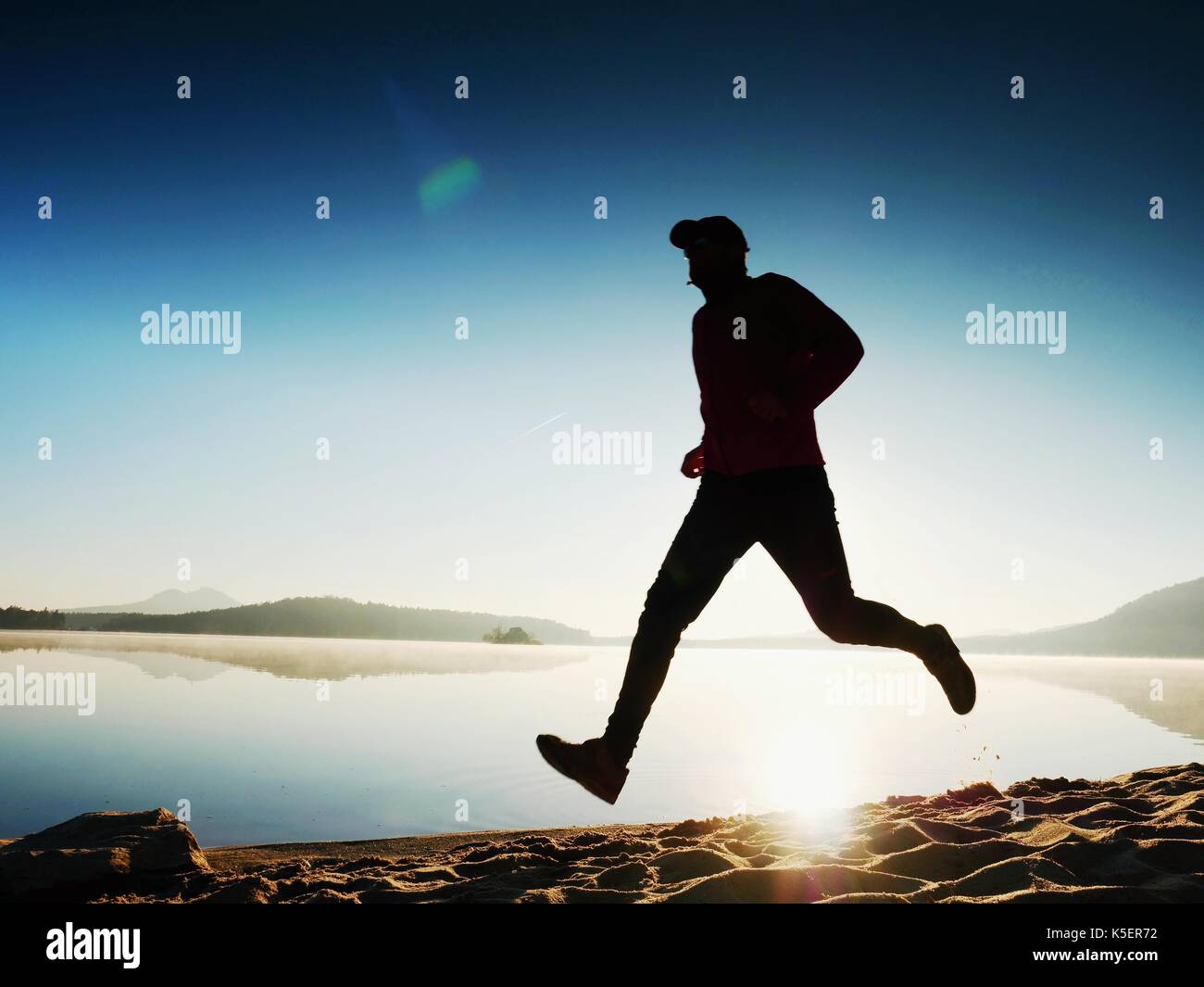 Running man on beach. Sportsman run in baseball cap, jogging guy during ...