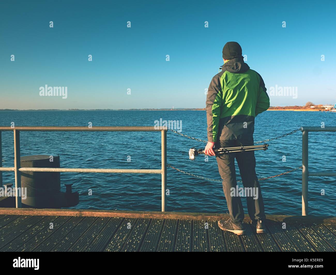 Alone artist on wooden sea bridge. Photographer with mirror camera and ...