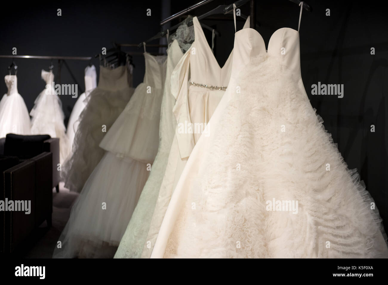 Selection of white wedding dresses or ball gowns on display hanging on ...