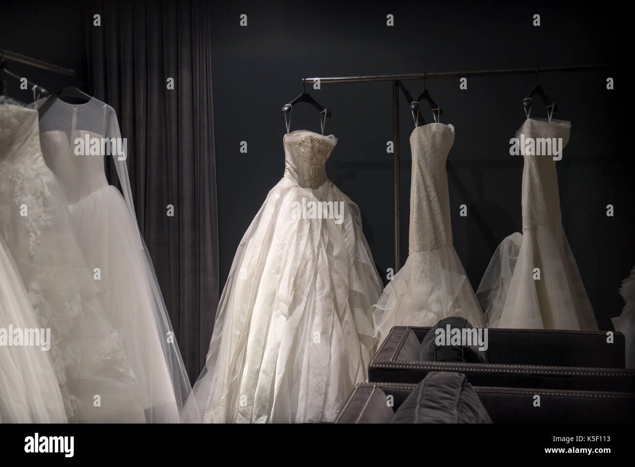 Selection of white wedding dresses or ball gowns on display hanging on ...