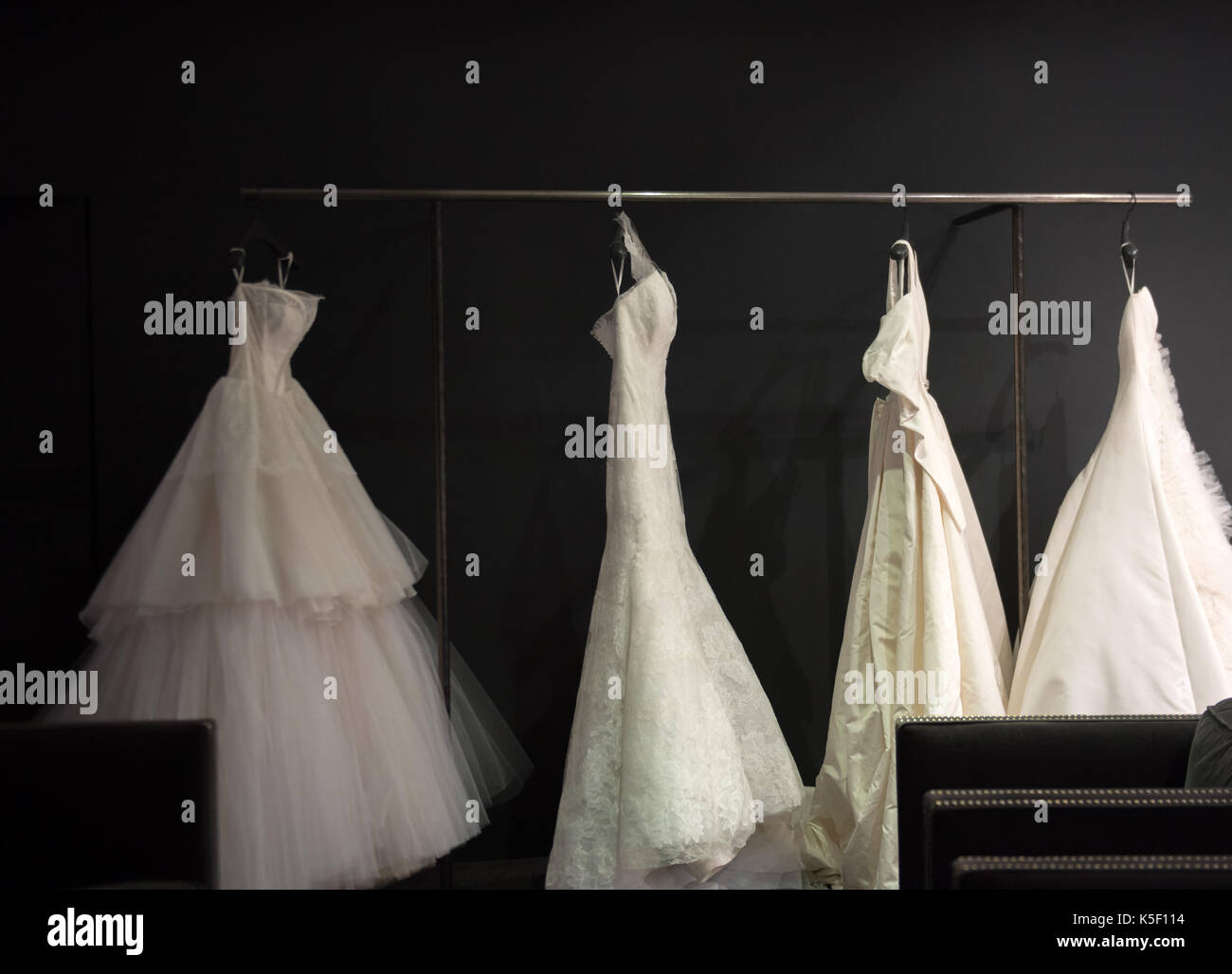 Selection of white wedding dresses or ball gowns on display hanging on ...