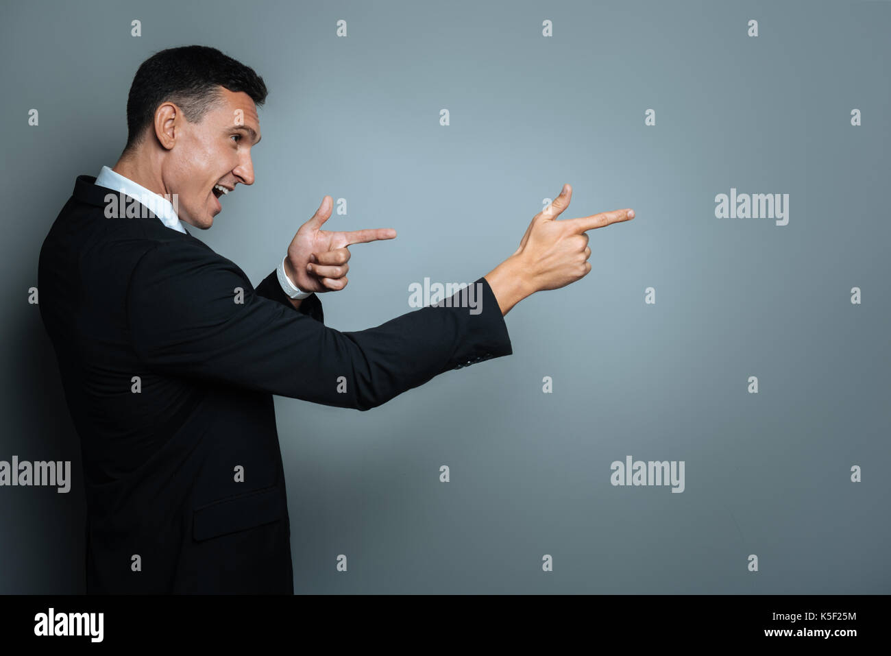 Happy joyful man pointing in front of him Stock Photo - Alamy