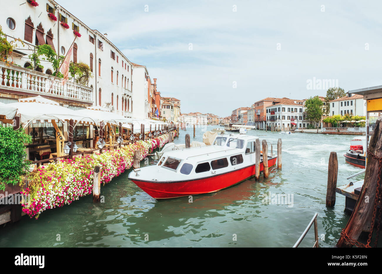 Green water channel with gondolas and colorful facades of old medieval ...