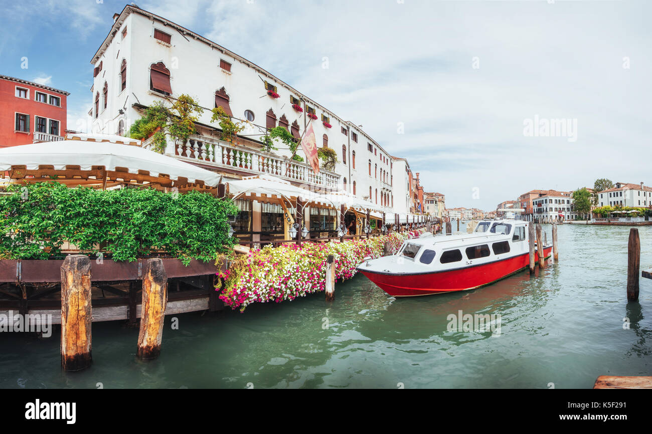Green water channel with gondolas and colorful facades of old medieval ...