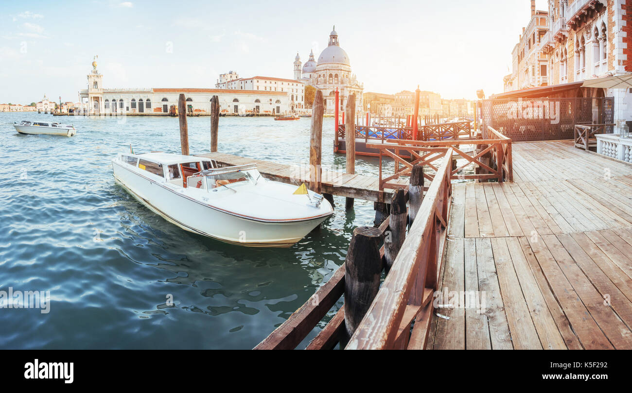 Green water channel with gondolas and colorful facades of old medieval ...