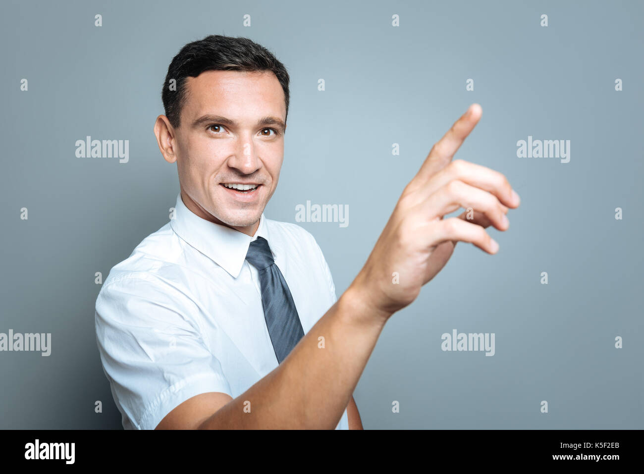 Delighted good looking man holding his hand up Stock Photo - Alamy