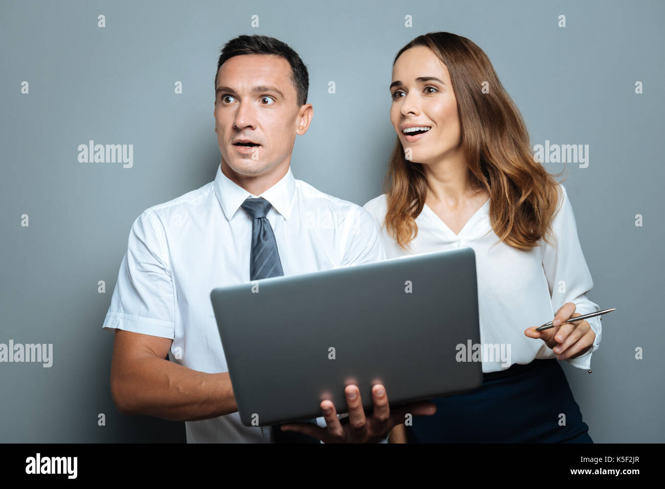 Positive nice colleagues looking surprised Stock Photo - Alamy