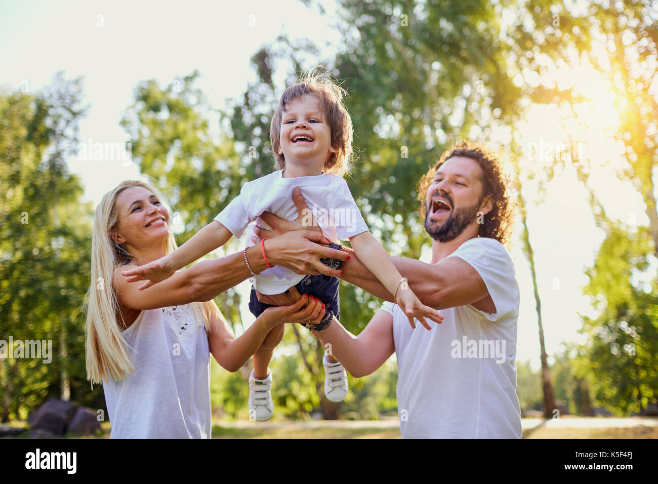 Happy family playing with a child in the park Stock Photo - Alamy