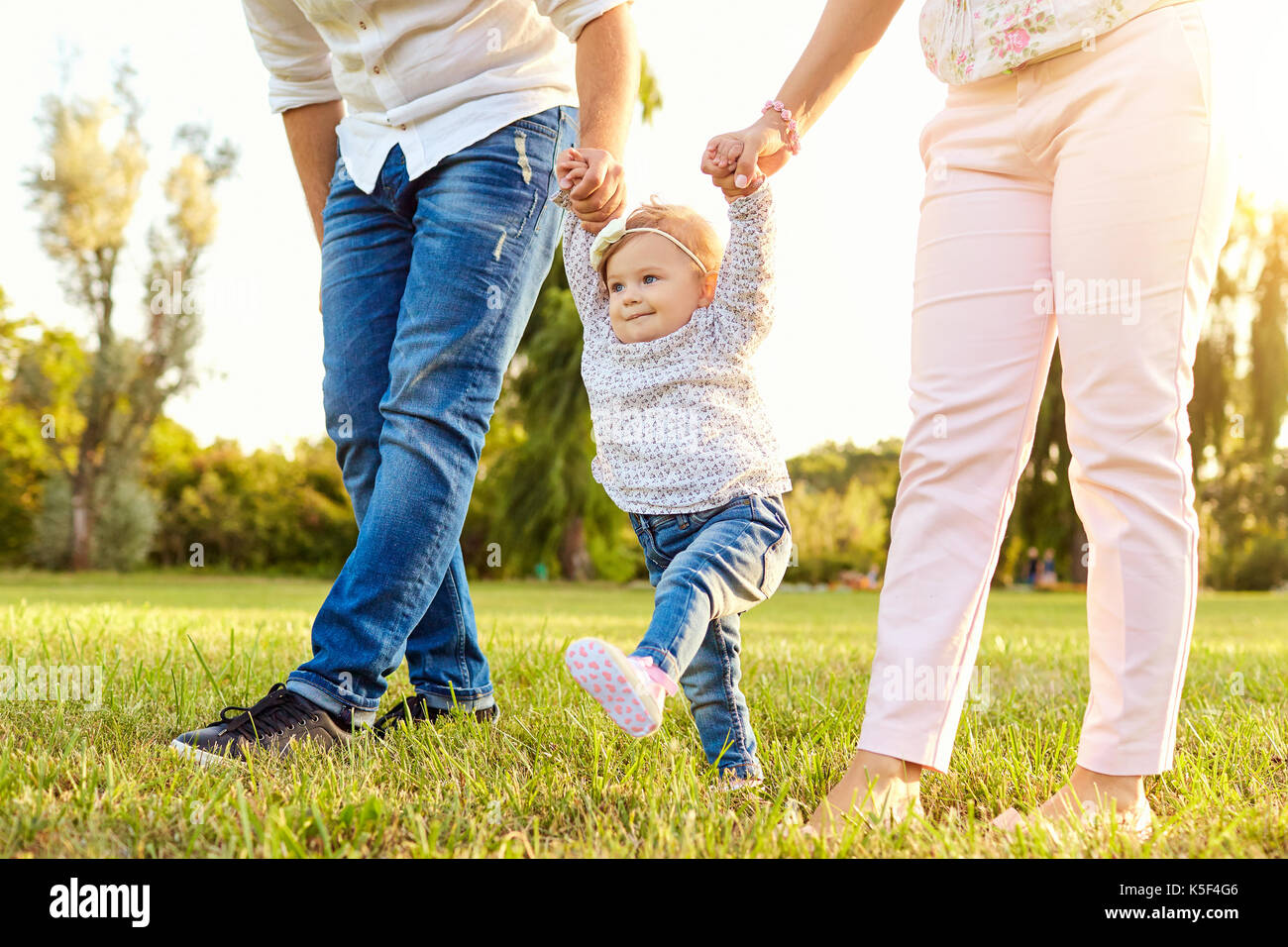 The first steps of the baby. A happy family Stock Photo - Alamy