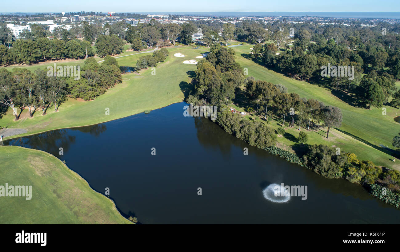 Aerial view of golf course dam with fountain surrounded by fairways ...