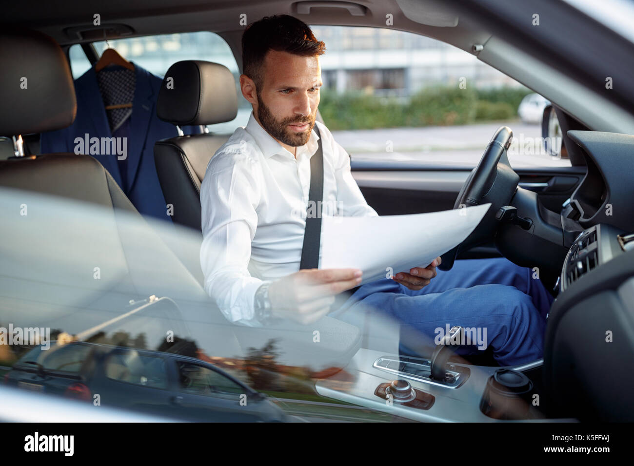 Serious businessman working paper work in the car Stock Photo - Alamy