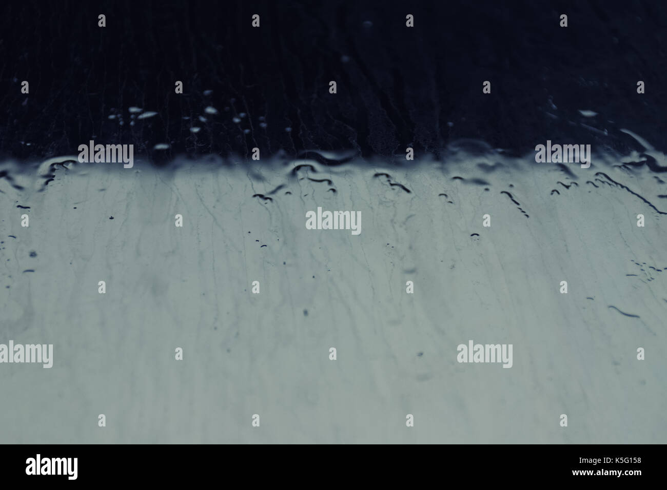 The rainwater stream pours from the dirty glass Stock Photo - Alamy