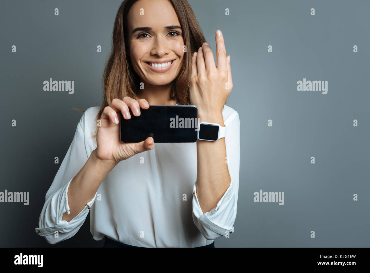 Happy cheerful woman showing her gadgets Stock Photo - Alamy