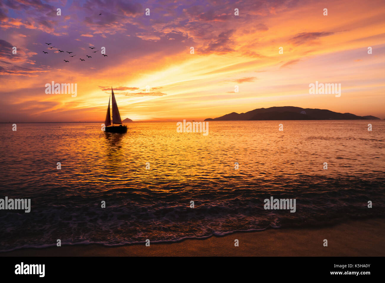 Sailboat on the ocean at beautiful sunrise Stock Photo - Alamy