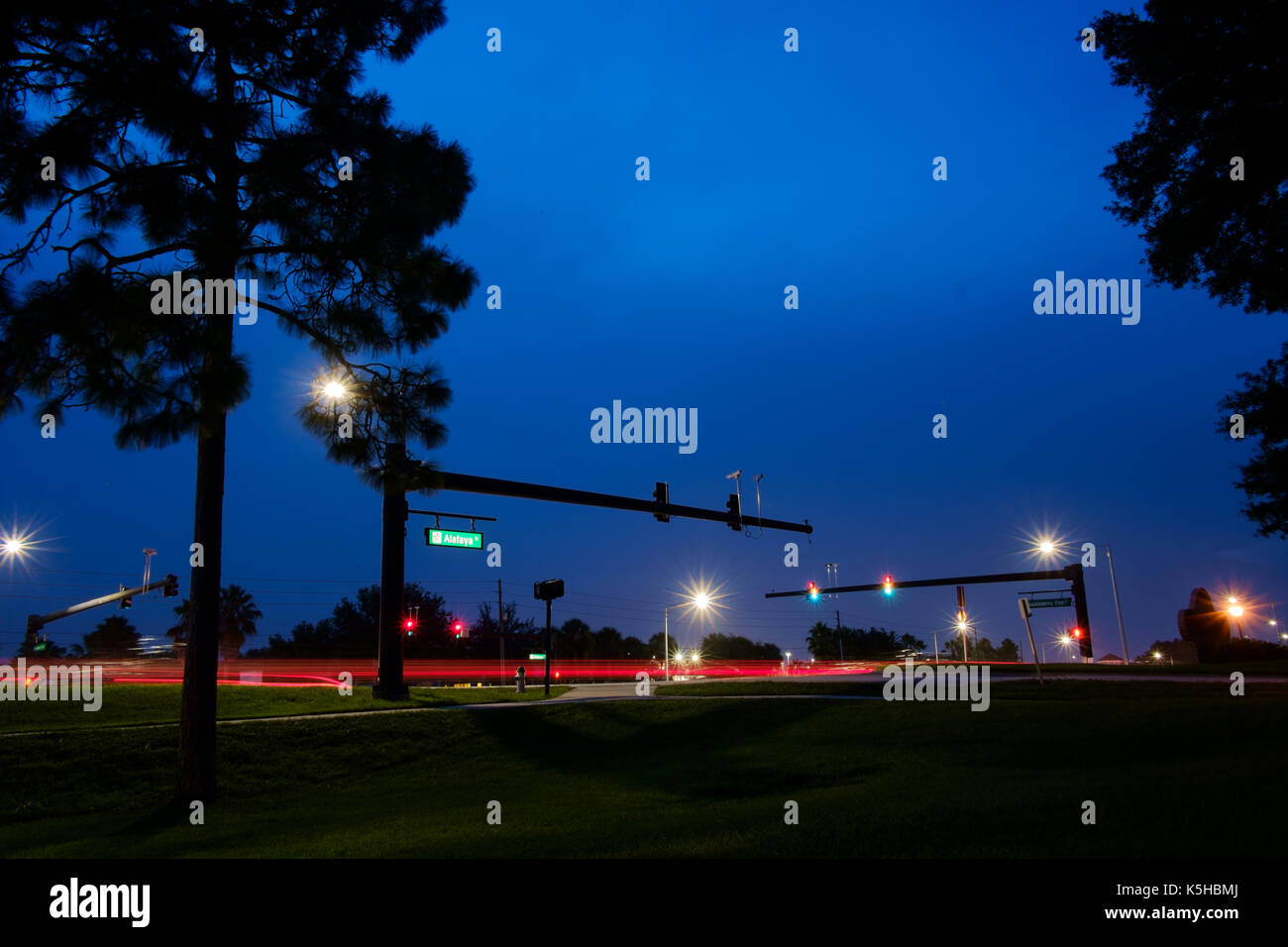 Crossroads at night with light streaks from passing vehicles Stock ...