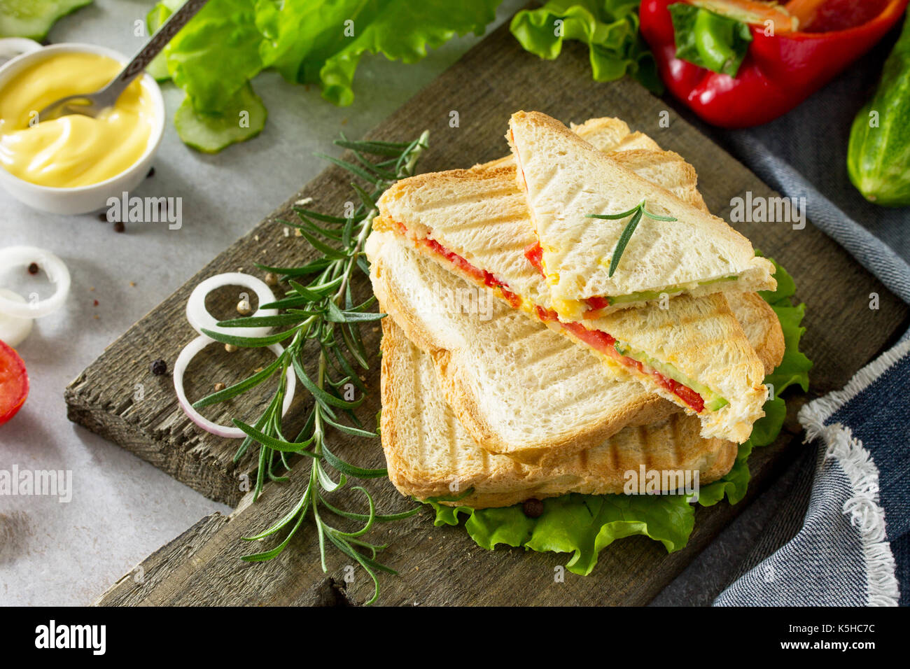double sandwich with fresh vegetables and cheese on a gray stone ...