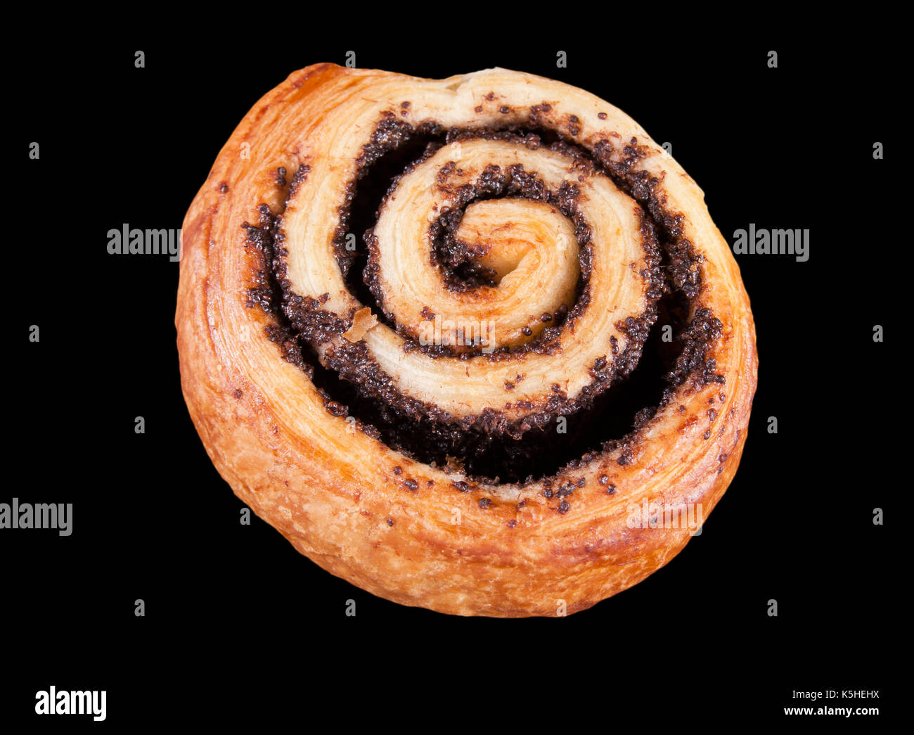 Snail bun with poppy seeds on the black background Stock Photo - Alamy