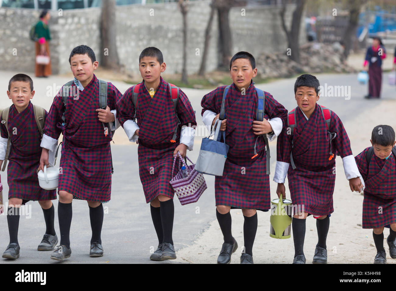 Schoolchildren on their way to the town school wearing traditional ...