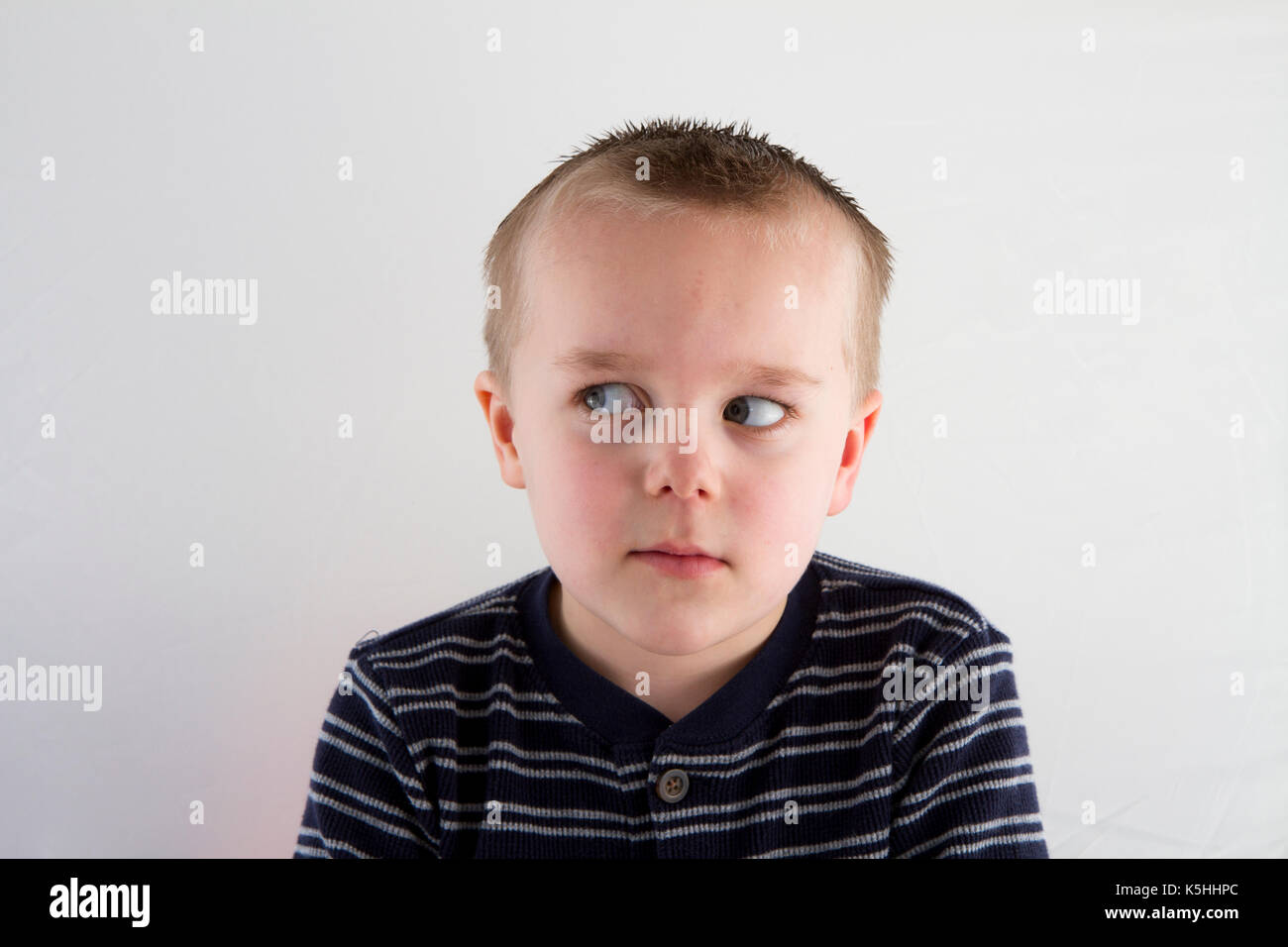 Young boy looking to the side curious Stock Photo - Alamy