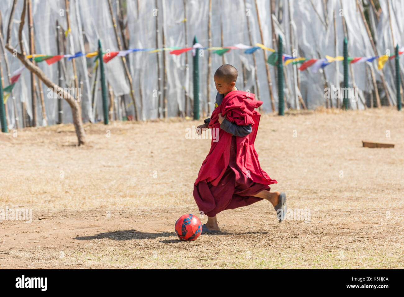 Young monk playing soccer at Chimi Lakhang (temple) near Lobesa ...