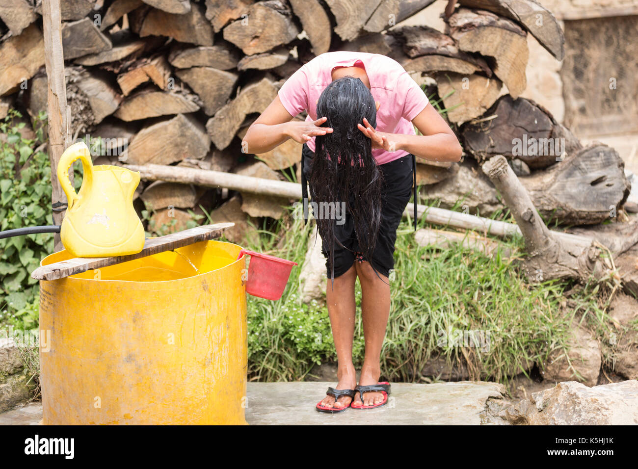 Young woman washing outside her house in Lobesa, Punakha, Western ...