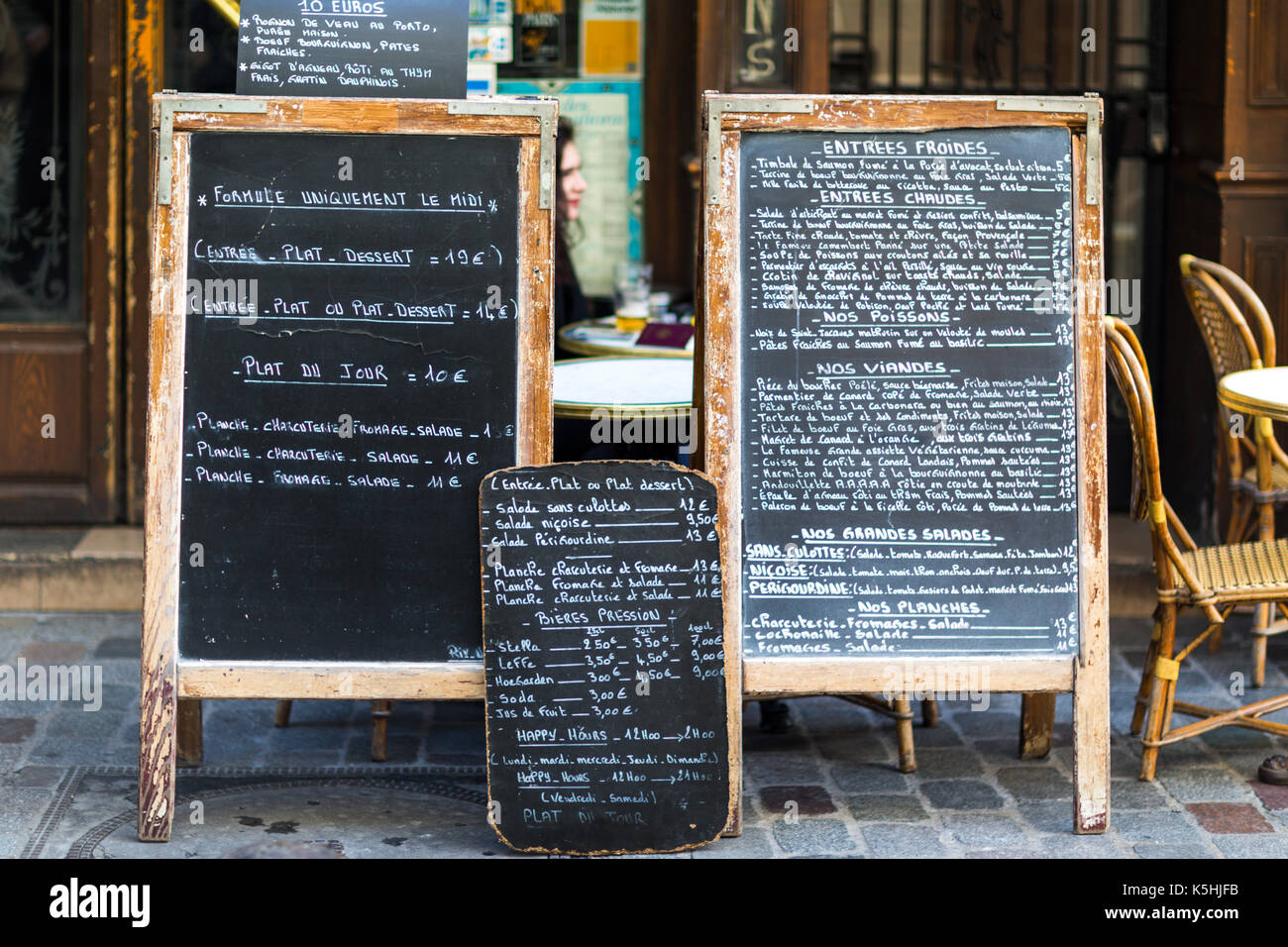 Menu boards and people eating outside at Les Sans Culottes restaurant ...