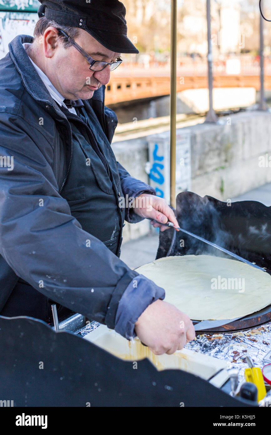 Street vendor making crepes on a mobile crepe stand by the Seine near ...