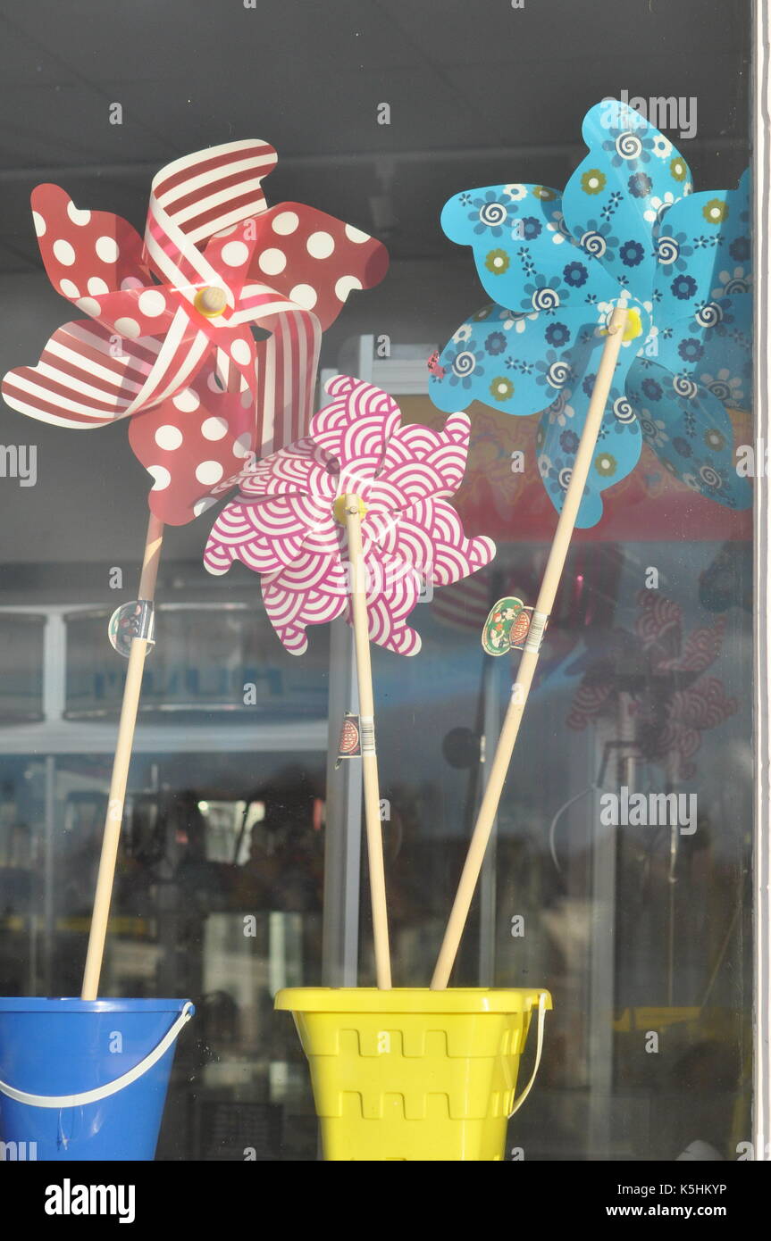 Brightly-coloured pinwheels in shop window Stock Photo - Alamy