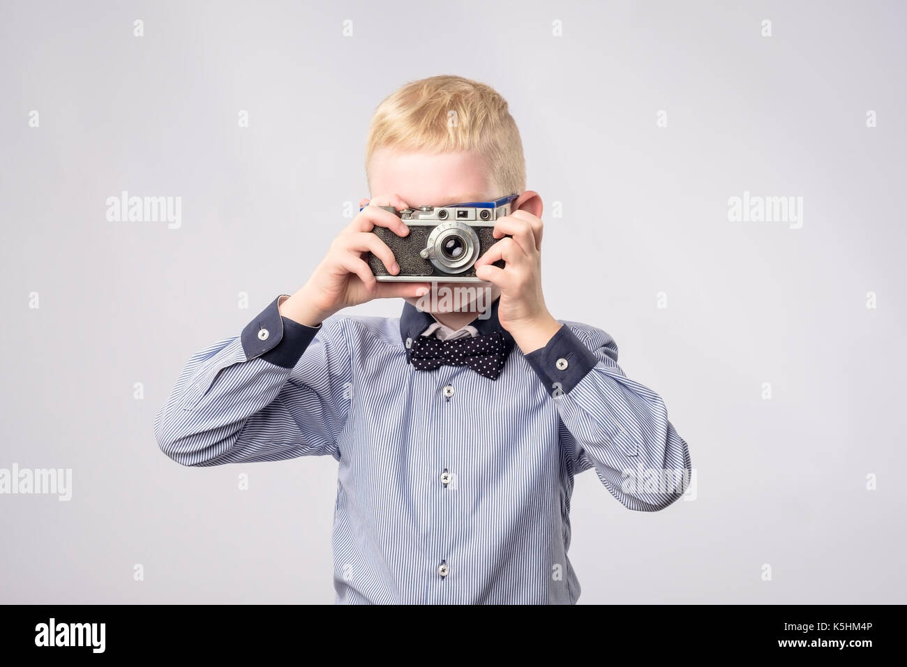 Cheerful smiling child boy holding a instant camera Stock Photo - Alamy
