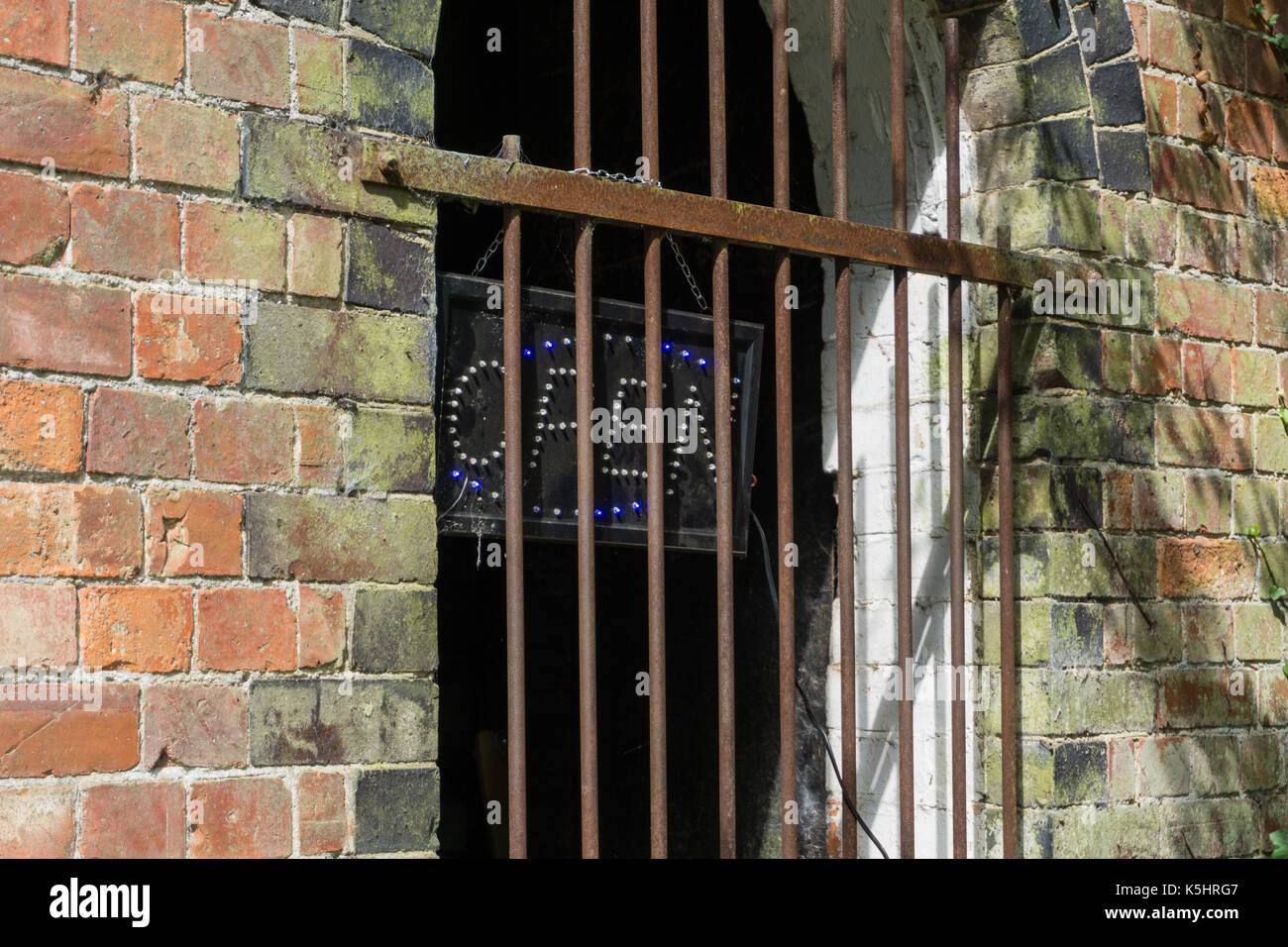 Electrically lit Open sign located behind a barred window Stock Photo ...