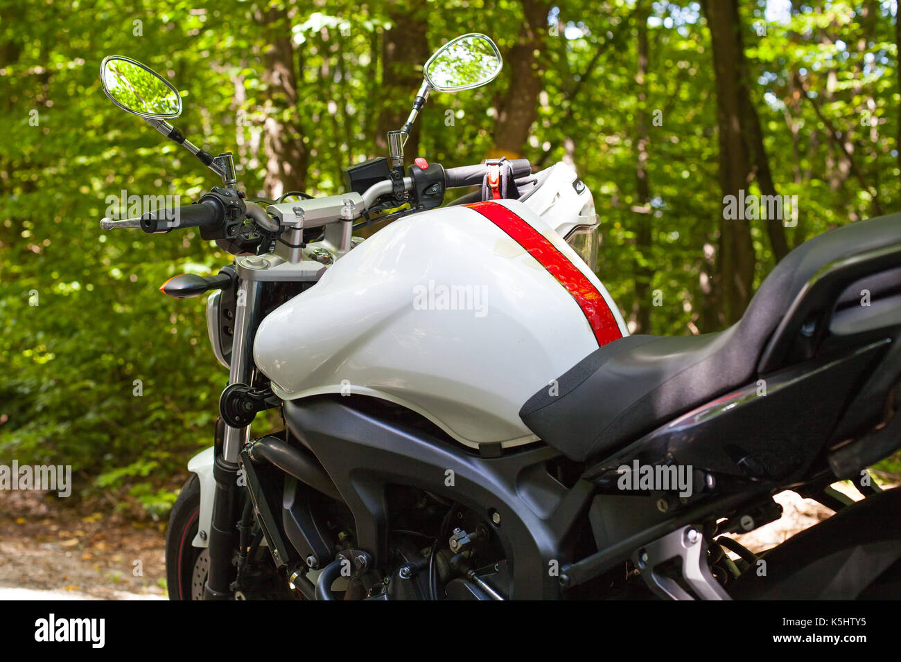 Picture of a motorcycle parked on a country road in a forest Stock ...