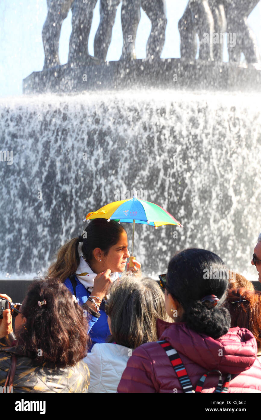 Tour guide talks to a crowd of tourists during a guided tour through ...