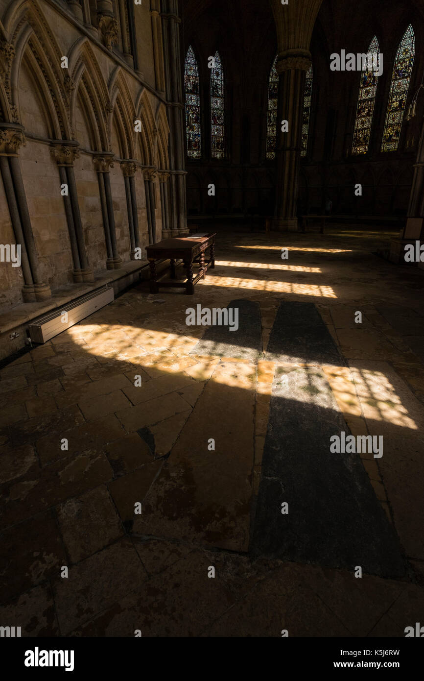 Sunlight through the stained glass windows casting shadows on the stone ...